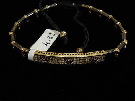 Златна гривна с черен конец черни ефектни мъниста и плочка с бели камъчета и коронки Златна