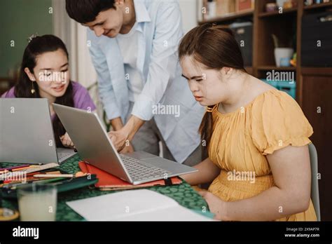 Woman With Down Syndrome Learning Through Laptop By Siblings At Home