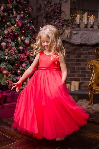 Premium Photo Little Blonde Girl In Evening Red Dress Near The