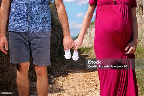 임신한 여자와 남자 아기 신발을 손에 들고 미래 엄마와 아빠 부모는 작은 신생아 신발 들고 있다 출생 기대 개념입니다 아기의 대기 임신 임신 어머니입니다 2명에 대한 스톡