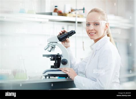 Smiling Woman Using Microscope In Laboratory Stock Photo Alamy