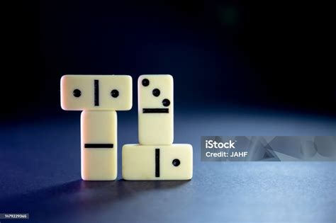 검은색 배경에 Dominò 타일 배치 및 다양한 모양으로 주문 스폿 조명 및 컬러 필터 보드 게임 개념 0명에 대한 스톡 사진