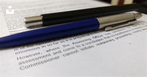 흰색 책 페이지에 두 개의 검은색과 파란색 클릭 펜 사진 Unsplash의 무료 인도 이미지