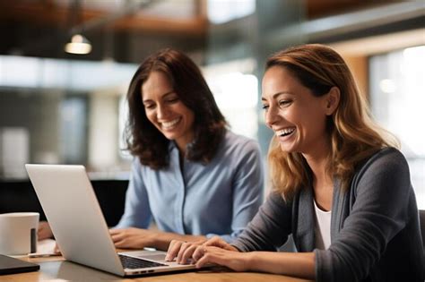 Premium Ai Image Happy Businesswoman With Colleague Using Laptop At Desk