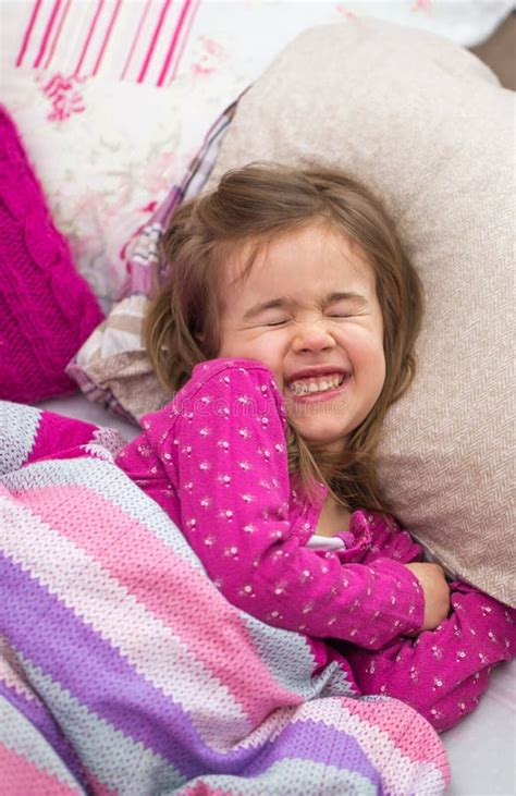 Маленькая девочка спать в розовой кровати Стоковое Изображение изображение насчитывающей