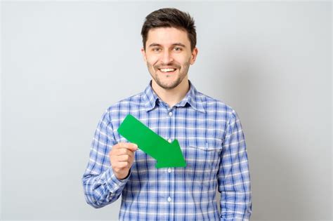 Premium Photo Man With Green Arrow Pointing To The Right And Down Isolated On Gray
