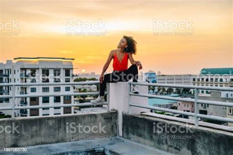 희망젊은 흑인 여자는 그녀의 뒤에 도시에서 일몰 동안 도시 옥상에 앉아 건물 외관에 대한 스톡 사진 및 기타 이미지 건물 외관 일몰 지붕 Istock