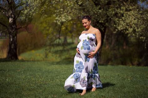 젊은 여행자 임신 한 여자 걷기 달리기 주위를 선회 하 고 꽃 패턴으로 여름 빛 긴 드레스를 입고 꽃 피는 사쿠라 벚꽃 나무 공원에서 그녀의 여가 자유 시간을 즐긴다 개념에