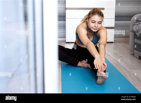 Sport Training And Lifestyle Concept Woman Stretching Leg On Blue