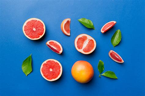 색으로 칠해진 배경에 육즙이 많은 자몽 슬라이스가 있는 신선한 과일 자몽 맨 위 보기입니다 공간을 복사합니다 창조적 인 여름 개념 복사 공간이있는 최소한의 평평한 평지에