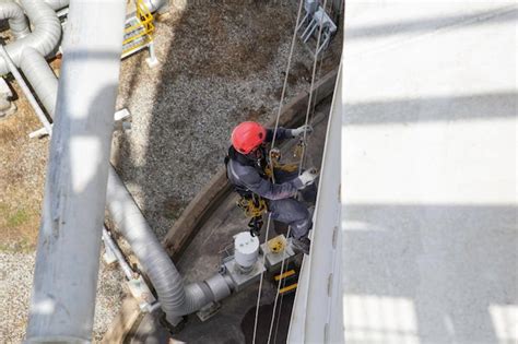 두께 저장 탱크의 남성 작업자 로프 접근 높이 안전 검사 프리미엄 사진