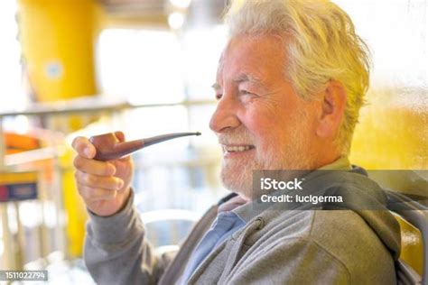야외 담배를 피우는 파이프에 앉아 있는 편안한 백발의 남자의 옆모습 자유 시간과 담배를 피우는 노인 수염 난 할아버지 담배 파이프에 대한 스톡 사진 및 기타 이미지 Istock