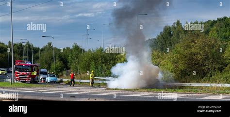 Fire Crew Putting Out A Car Fire After An Incident On The Motorway Uk