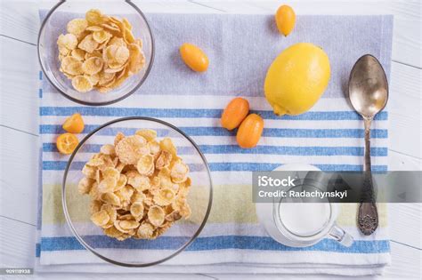 콘플레이크와 그릇 우유와 준비 된 맛 있는 아침 식사에 대 한 빈 그릇의 용기 우유와 과일 나무 테이블 평면도 콘플레이크 건강 한 아침 식사의 개념 평평 하다 0명에 대한