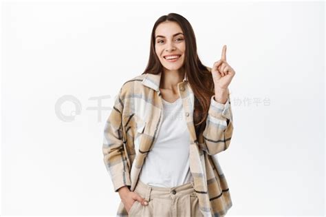 美丽的腼腆女人指着手指咯咯笑可爱地微笑展示广告在顶部复制空间上展示产品横幅或公司徽标站在白墙上动物植物免费下载 jpg格式 编号