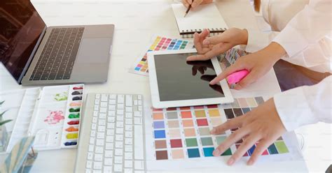 직장에서 팀 그래픽 디자이너 그래픽 디자이너는 사무실에서 컬러 톤 용지 태블릿 및 컴퓨터를 작업합니다 사진 Unsplash의 사무실 이미지