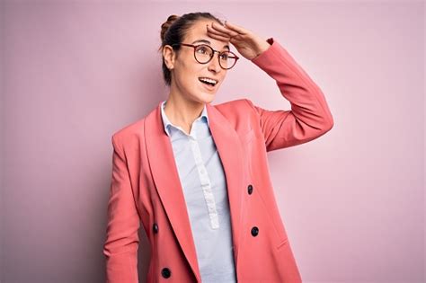 고립 된 분홍색 배경 위에 재킷과 안경을 착용한 젊은 아름다운 사업가는 매우 행복하고 머리 위로 손으로 멀리 보고 미소 개념 검색 한 명의 여자만에 대한 스톡 사진 및 기타