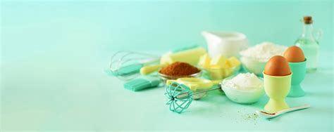 구워 시간 베이킹 재료버터 설탕 밀가루 계란 기름 숟가락 롤링 핀 브러시 거품 기 파란색 배경 위에 우유 빵집 음식 프레임 요리 개념입니다 복사 공간 배경 주제에 대한 스톡