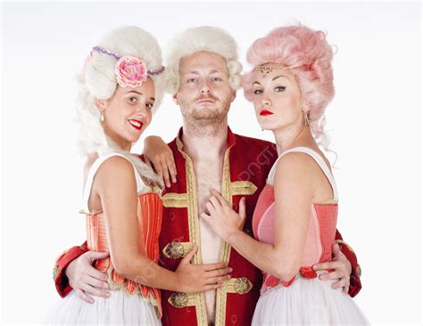A Man Embraced By Two Women Dressed In Historical Outfits Signifying