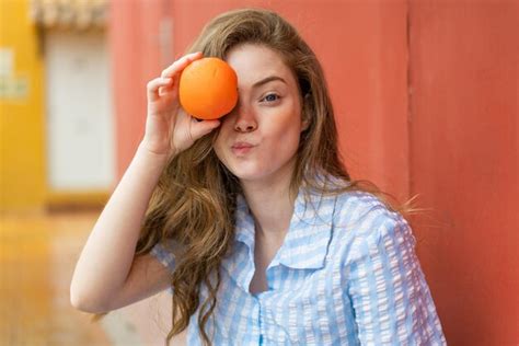 Premium Photo Young Redhead Woman At Outdoors Holding An Orange