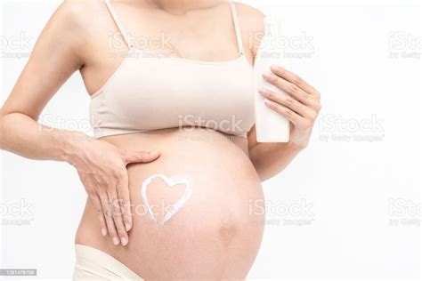 스트레치 마크를 방지하기 위해 배에 로션을 적용 배 젊은 임신 모델의 클로즈업 미래의 엄마는 그녀의 배에 보습 크림을 문질러 임신 스킨케어 컨셉 보습제에 대한 스톡 사진 및