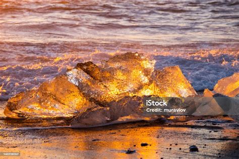 해질녘 검은 화산 모래에 빛나는 빙산 맑은 얼음이 파도에 부딪쳤다 북유럽 국가의 유명한 관광지 아이슬란드의 다이아몬드 비치 여행 목적지 고해상도 검은색에 대한 스톡 사진 및