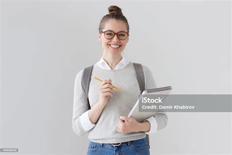 실내 서 손과 연필 연구에 대 한 새로운 정보를 주의 하는 준비에 큰 노트북와 회색 배경에 절연 또는 자유롭게 Hipster 안경에 좋은 젊은 유럽 여자의 초상화 여자에