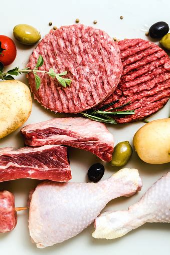 다양 한 종류의 생고기 닭고기 허벅지 돼지고기와 쇠고기 버거 갈비와 케밥 칠면조 미트볼 감자 고추 올리브 및 검은 올리브와 향기로운 허브로 조리 할 준비가 되어 있습니다