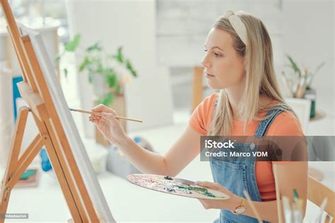 이젤과 유성 페인트를 사용하여 캔버스에 그림을 그리는 스튜디오나 작업장에서 여성과 함께 붓 예술 또는 창작 수채화 영감 팔레트