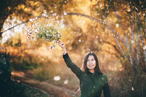 노란 잎과 Bokeh 배경에 엉 겅 퀴 꽃과 꿈꾸는 아름 다운 소녀 흰색은 황금빛 햇빛에 보풀입니다 가을 숲에서 영감을 받은 소녀 엉 겅 퀴의 포자 비행 중 여성의 아름다움