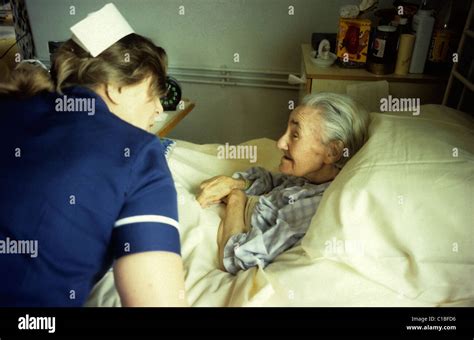 An Nhs Nurse In A Blue Uniform Showing Compassion And Empathy Leaning