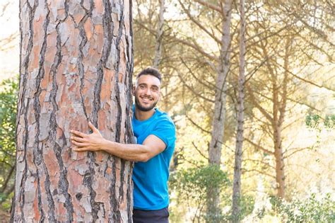 Free Photo Man Hugging Tree In Lovely Forest