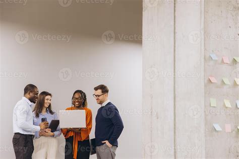 Business Team Collaborating Using Digital Devices Near Concrete Wall