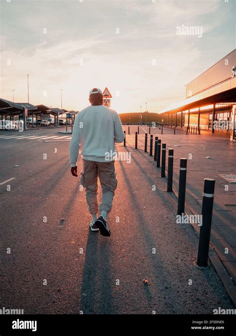 A Back View Of An African American Male Walking In The Parking Lot