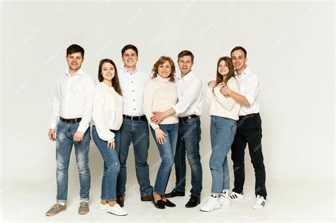 7명이 있는 젊은 가족이 흰색 배경에서 즐거운 시간을 보내고 있습니다 행복한 사람들 다양한 국적과 연령대의 사람들이 껴안고 있습니다 프리미엄 사진