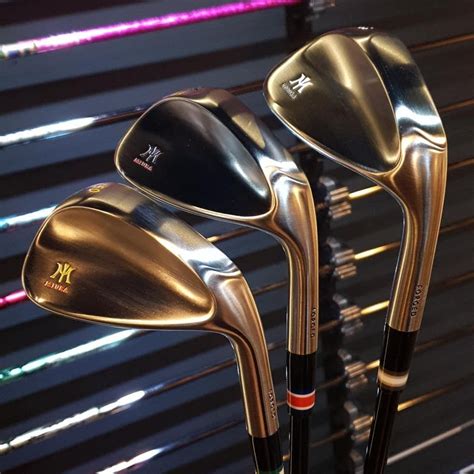 Three Golf Clubs Are Lined Up On A Racket
