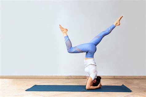 아도 무카 Vrksasana 운동에 서 요기 소녀 요가 스튜디오에서 연습하는 헤드 스탠드에 여자 아래쪽을 향한 트리 포즈 복사 공간 건강한 생활방식에 대한 스톡 사진 및