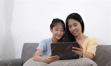 Premium Photo Happy Young Asian Mom And Daughter Using Digital Tablet