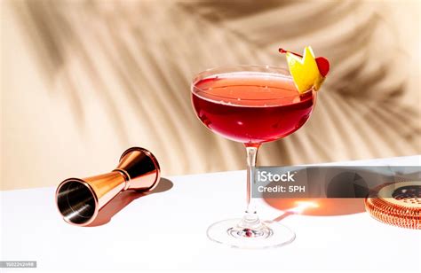 위스키 석류석 비터 레몬 얼음을 곁들인 뉴요커 레드 칵테일에 레몬 제스트와 칵테일 체리를 잔에 담았습니다 베이지색 배경 하드 라이트 칵테일에 대한 스톡 사진 및 기타 이미지