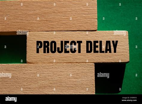 Project Delay Message Written On Wooden Block With Green Background