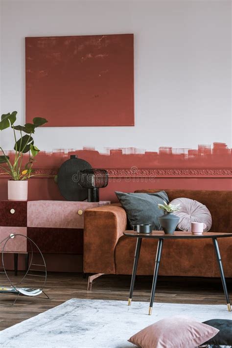 Suede Burgundy And Pastel Pink Commode With Black Vase With Green Leaf