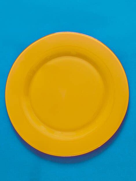Premium Photo Empty Yellow Plate On Blue Background