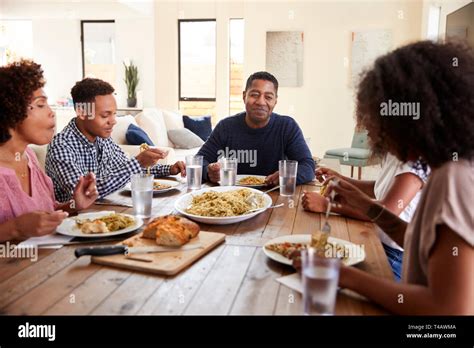 Middle Aged Black Man Sitting At The Table Eating Dinner With His Wife