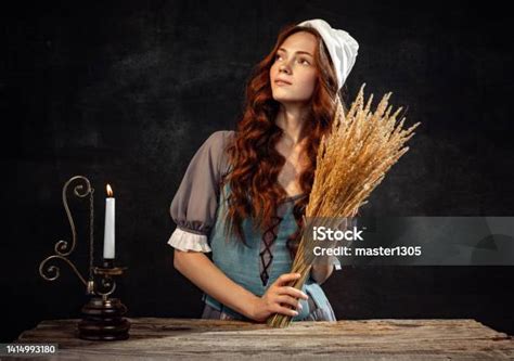 어두운 배경에 고립 된 르네상스 스타일의 드레스에서 중세 인물의 이미지에 긴 곱슬 머리를 가진 젊은 아름다운 빨간 머리 소녀의 창조적 인 초상화 20 24세에 대한 스톡