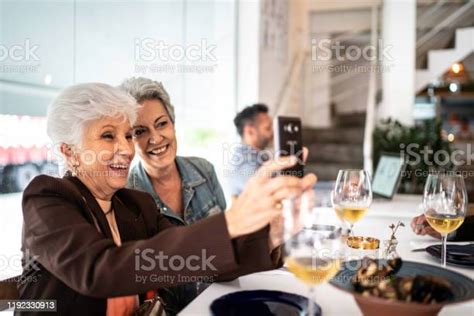 레스토랑에서 점심을 먹으면서 셀카를 찍는 선임 친구 여성 60 64세에 대한 스톡 사진 및 기타 이미지 60 64세 70 79세 가족 Istock