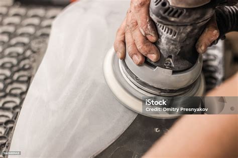 연삭기를 사용한 헤드 라이트 유리 복원 한 남자가 주유소에서 연마기로 자동차 헤드라이트의 광학 장치를 연마합니다 연마 기계로