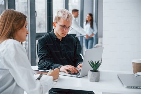 노트북으로 사무실에서 실내에서 함께 일하고 의사 소통하는 여성과 남성의 모습을 닫습니다 사진 Unsplash의 우크라이나 이미지