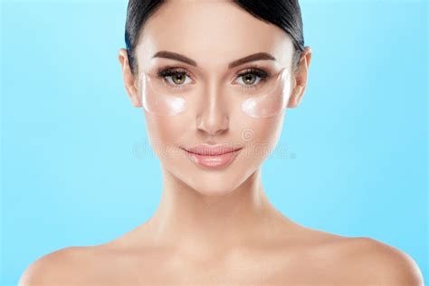 Perfect Girl With Nude Make Up And Naked Shoulders At Studio Background