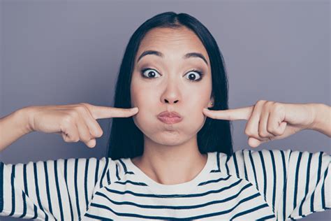 좋은 귀여운 매력적인 재미 스트레이트 머리 여자 스트라이프 풀 오버 Forefingers 회색 파스텔 배경에 고립 된 감동 하는 뺨에 공기를 들고의 클로 우즈 업 초상화