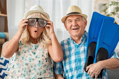 모자를 쓰고 수영 안경을 쓰고 앉아 있는 여행사에 앉아 있는 선배 부부는 카메라를 보고 웃는 얼굴을 하고 있다 고객에 대한 스톡 사진 및 기타 이미지 Istock